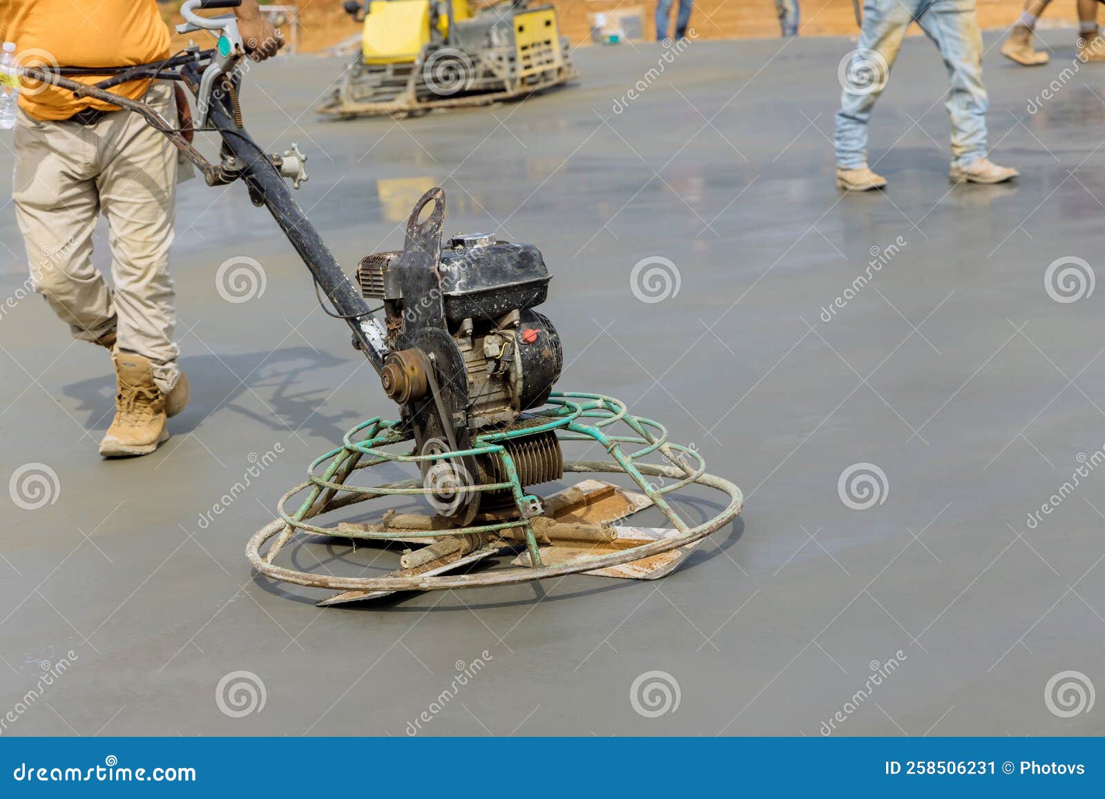 In a Construction Site, a Worker Polishes and Levels a Cement Screed ...