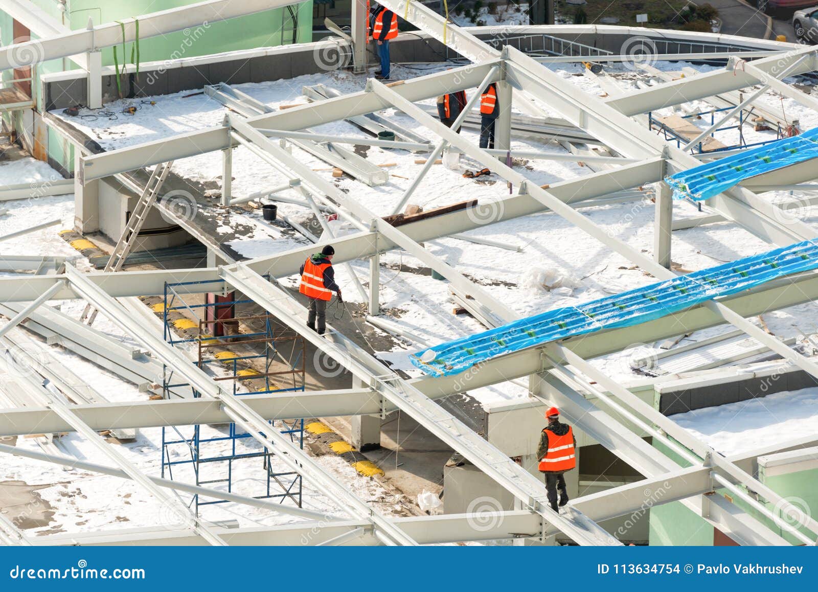 Building Roof Construction Insulation Works. Worker With Yellow Vest At ...