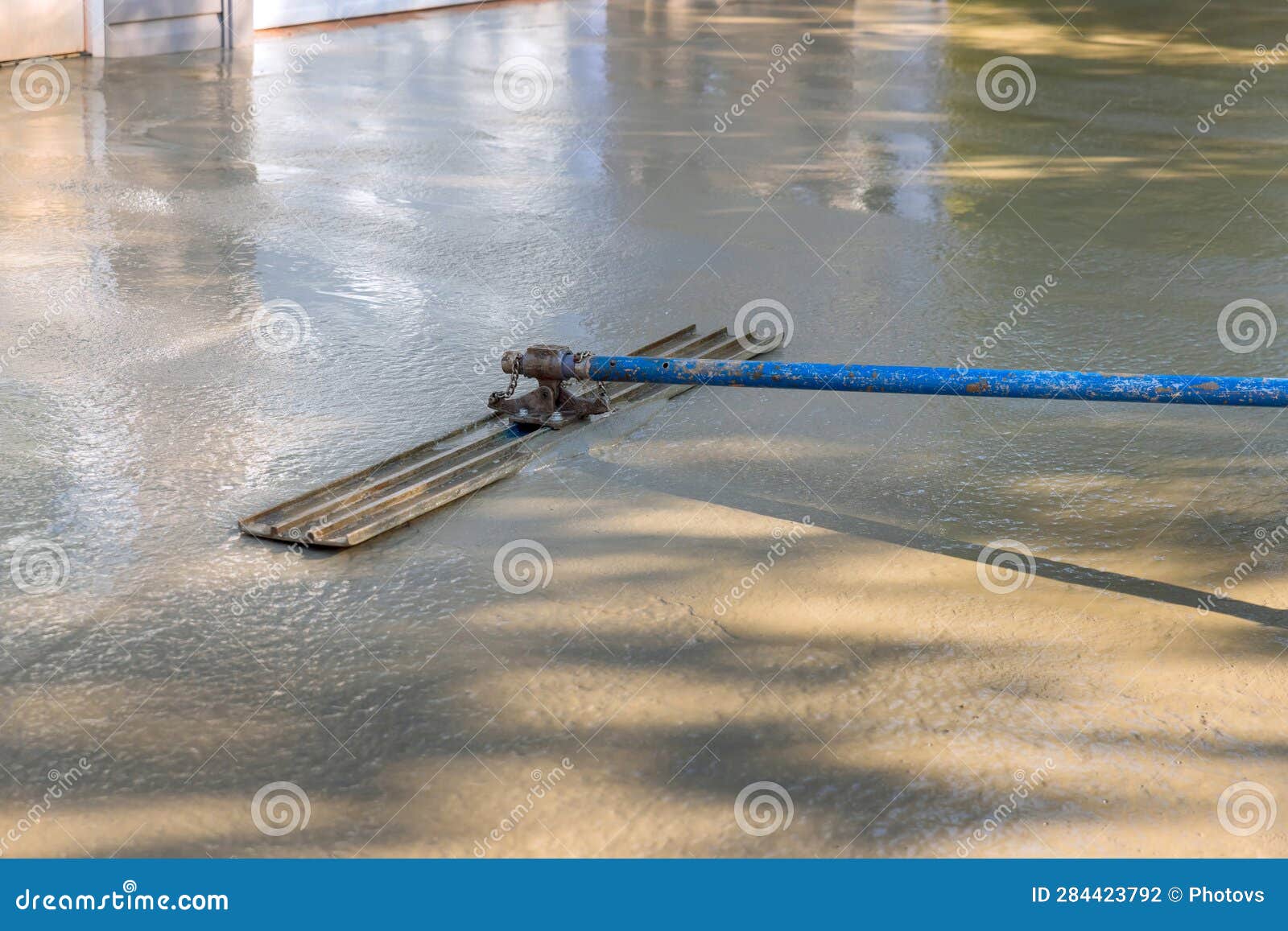 In Construction Site, Workers are Leveling Concrete for Driveway with a ...