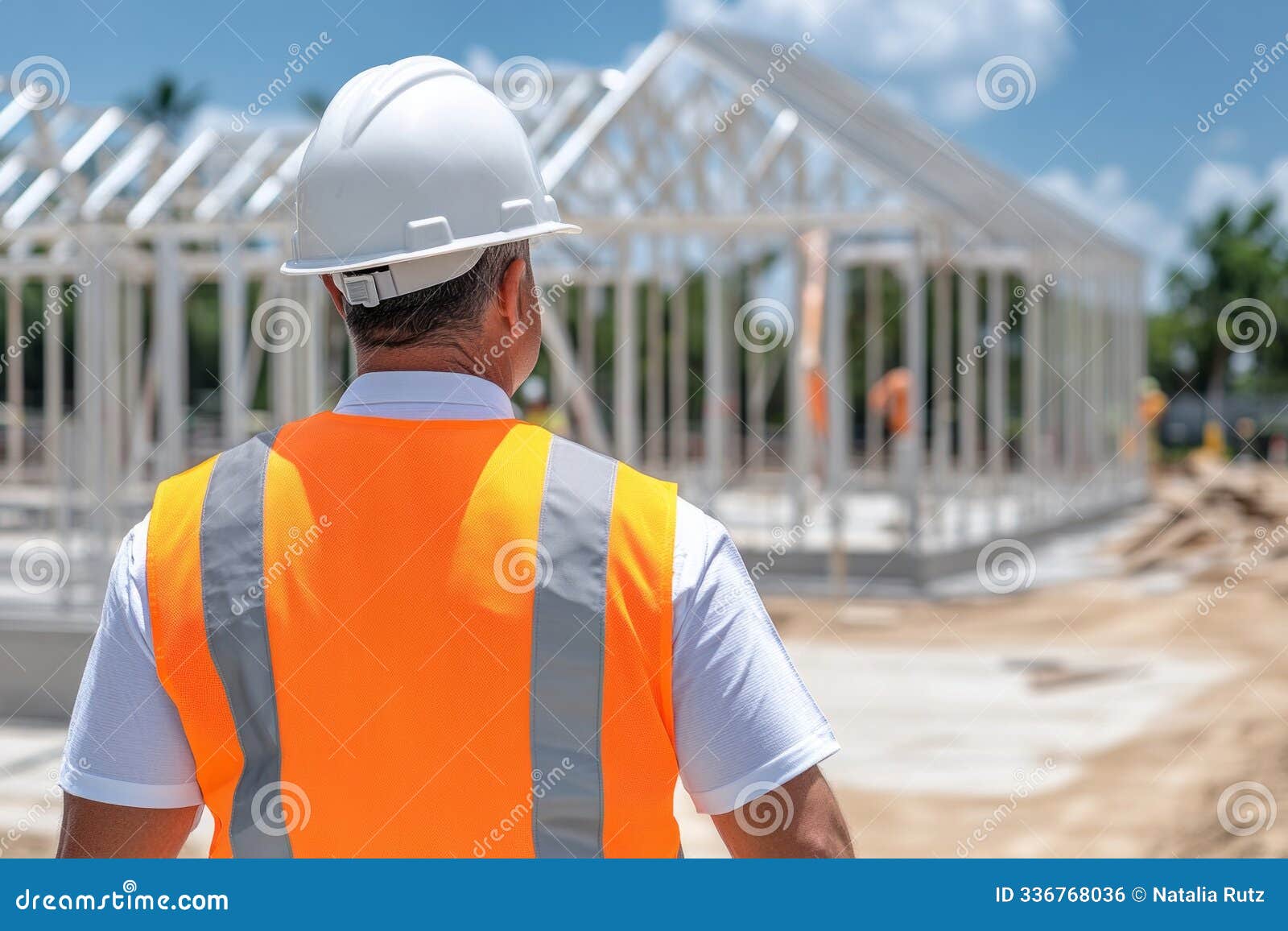 A Construction Supervisor in a Hard Hat and Reflective Vest Oversees ...