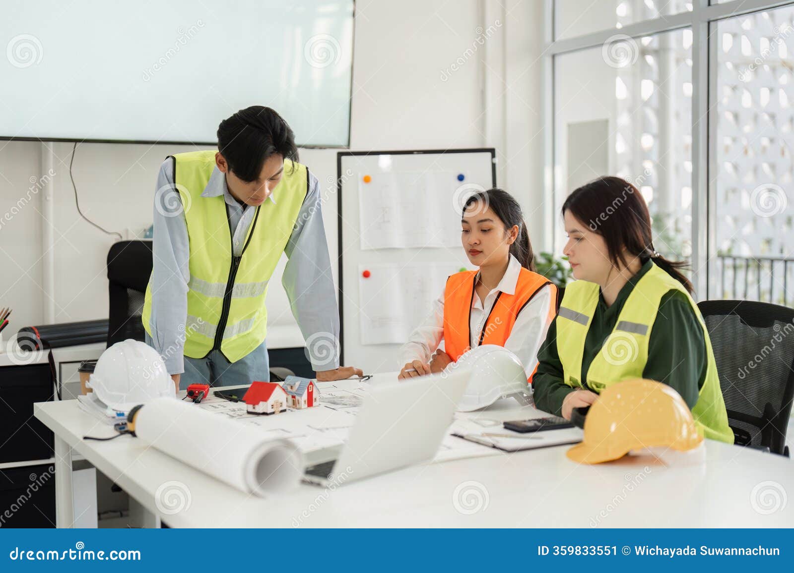 Construction Team Collaborating on Architectural Plans in Modern Office ...