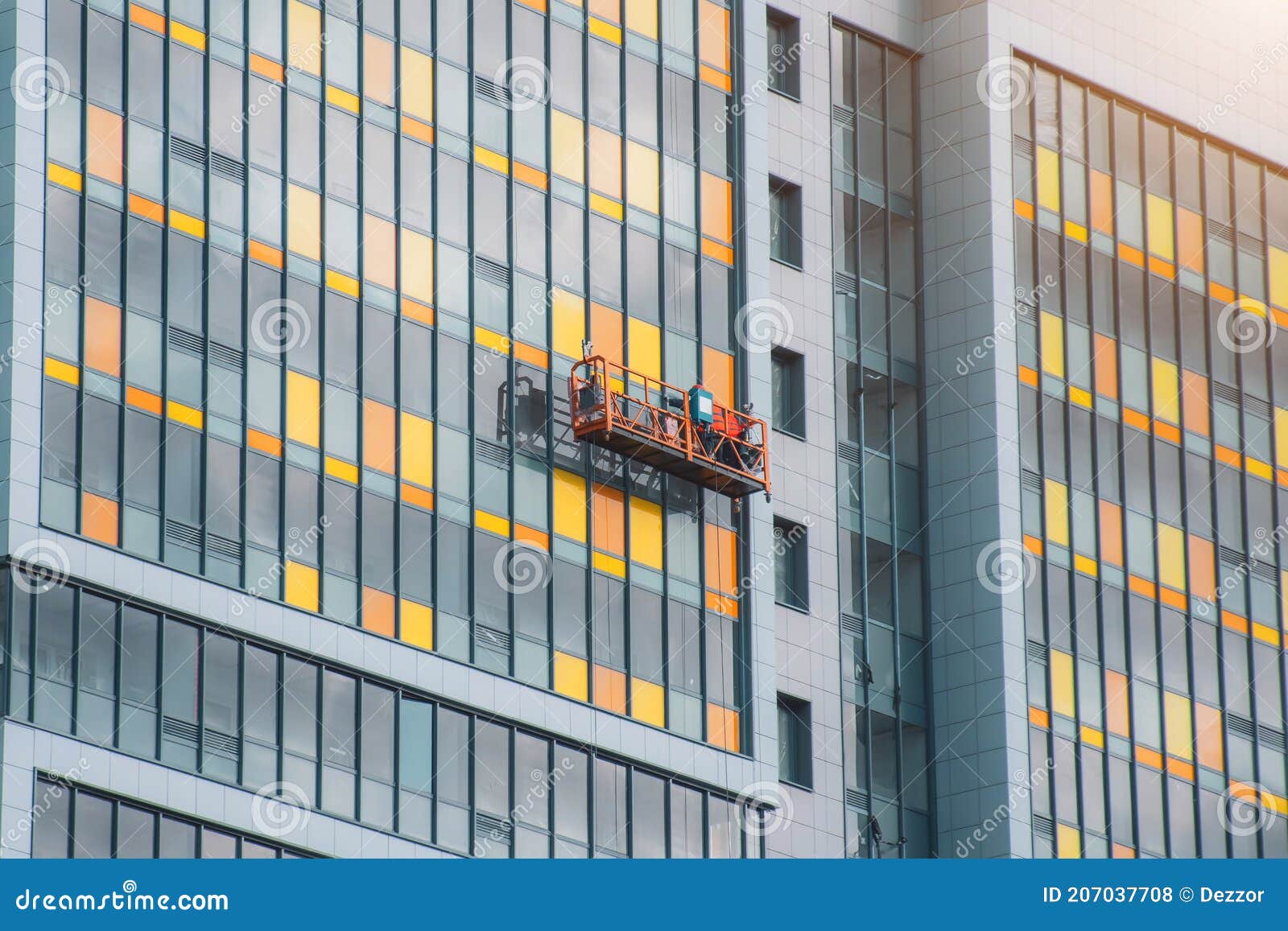 A Construction Team in a Suspended Cradle on Cables is Working on the ...
