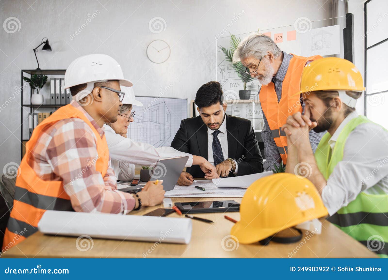 Construction Team Working with Blueprints and Modern Devices at Office ...