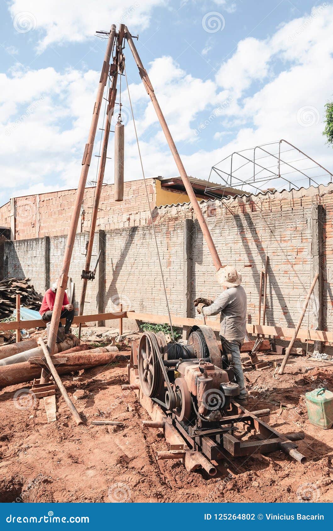 Using a Pile Driver on a Tripod To Dig the Soil and Make the Foundation ...