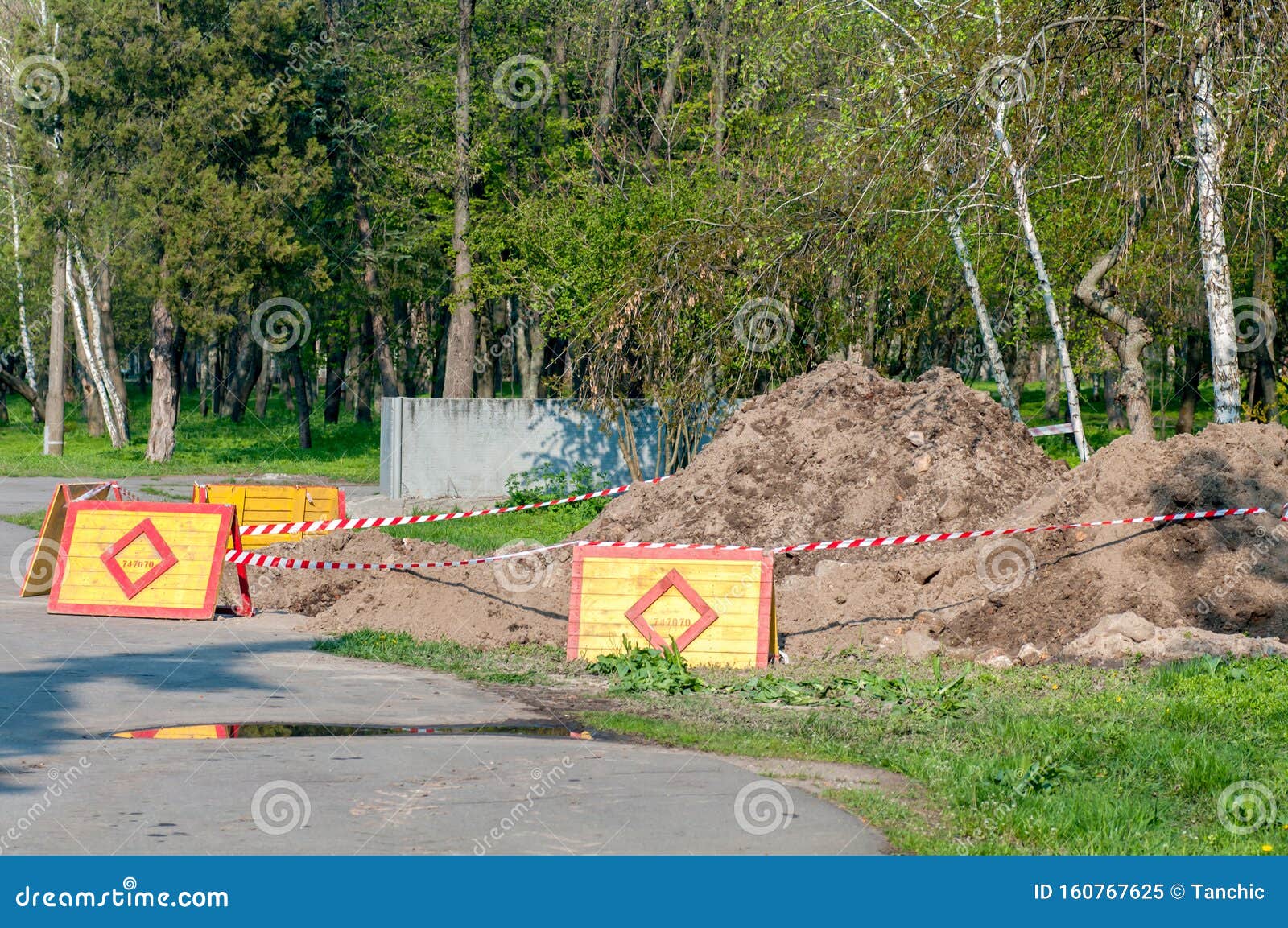 Construction Work, a Dug Hole with a Warning Sign in the Park Stock ...