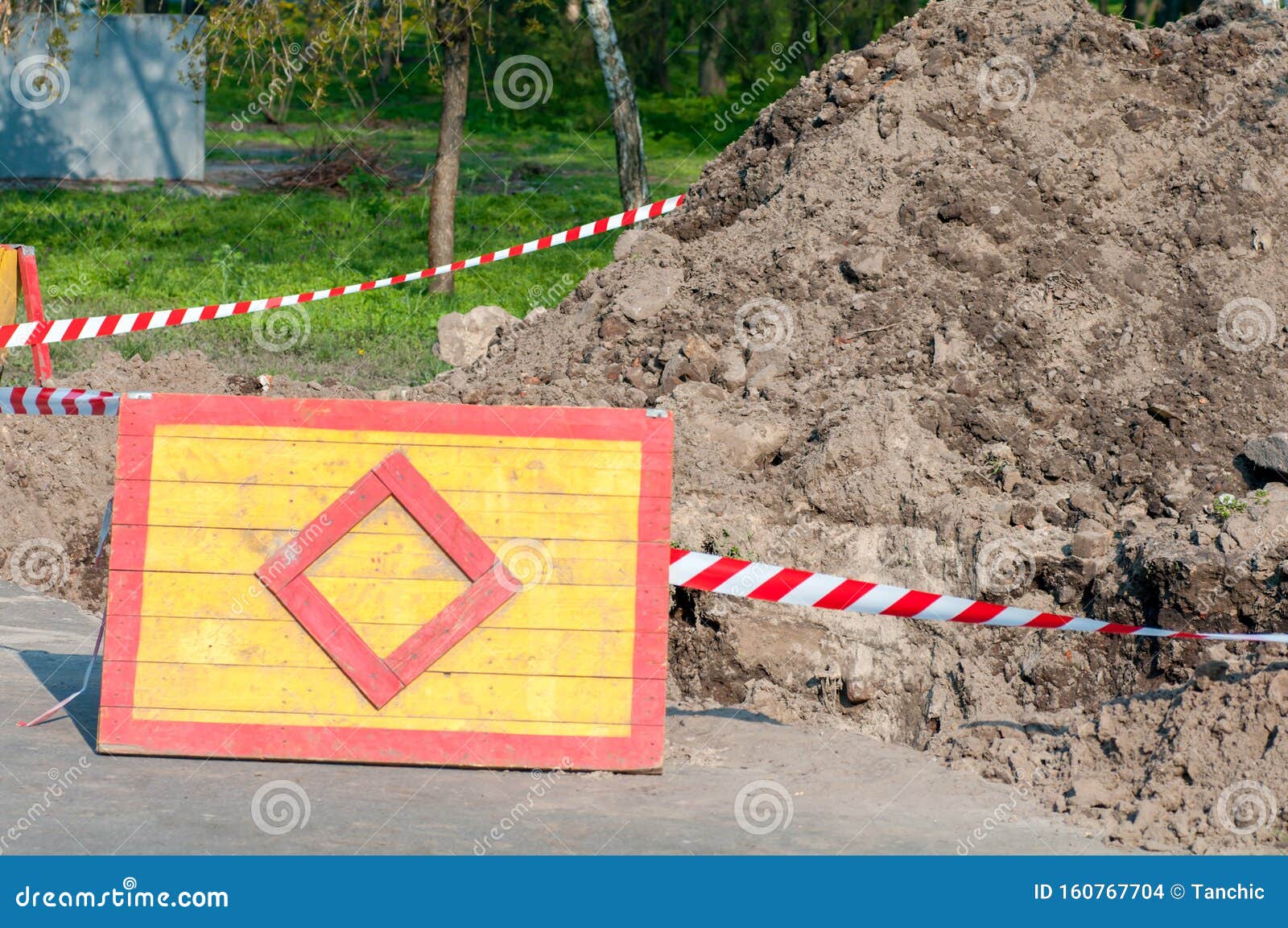 Construction Work, a Dug Hole with a Warning Sign in the Park Stock ...