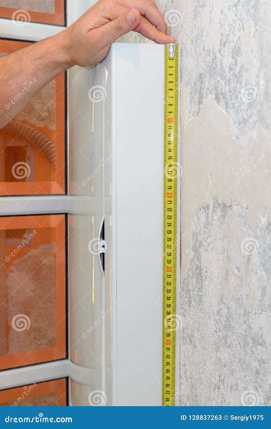 Construction Work, A Worker Measures The Wall With A Building Tape ...