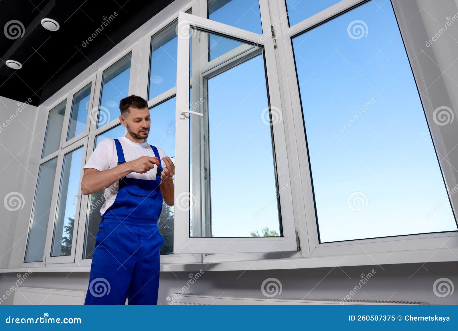 Construction Worker Adjusting Installed Window with Screwdriver Indoors ...