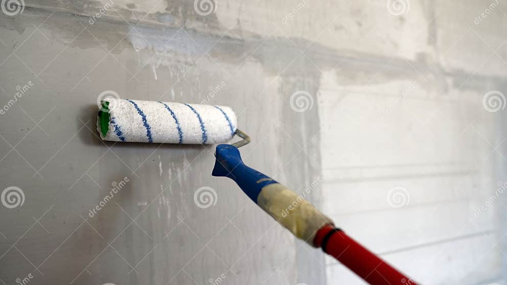 Construction Worker Applying Plaster on the Wall Using a Roller. Stock ...