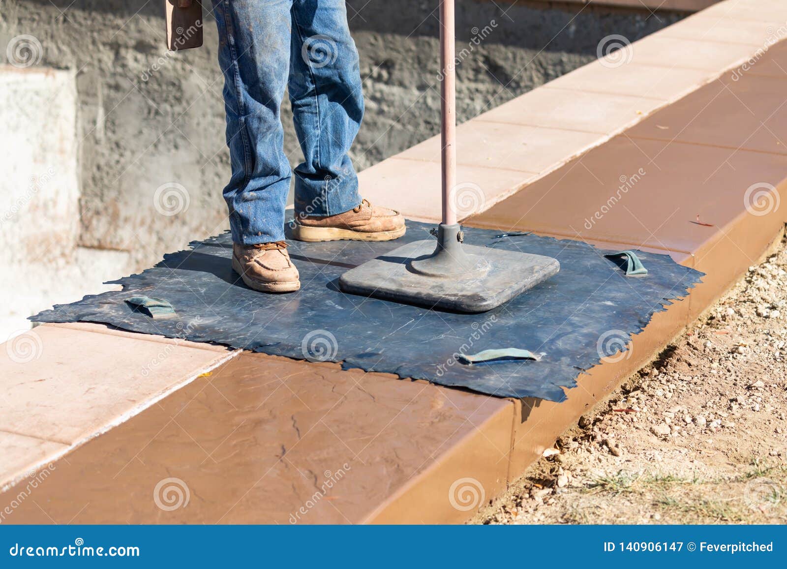 Construction Worker Applying Pressure To Texture Template on Wet Cement ...