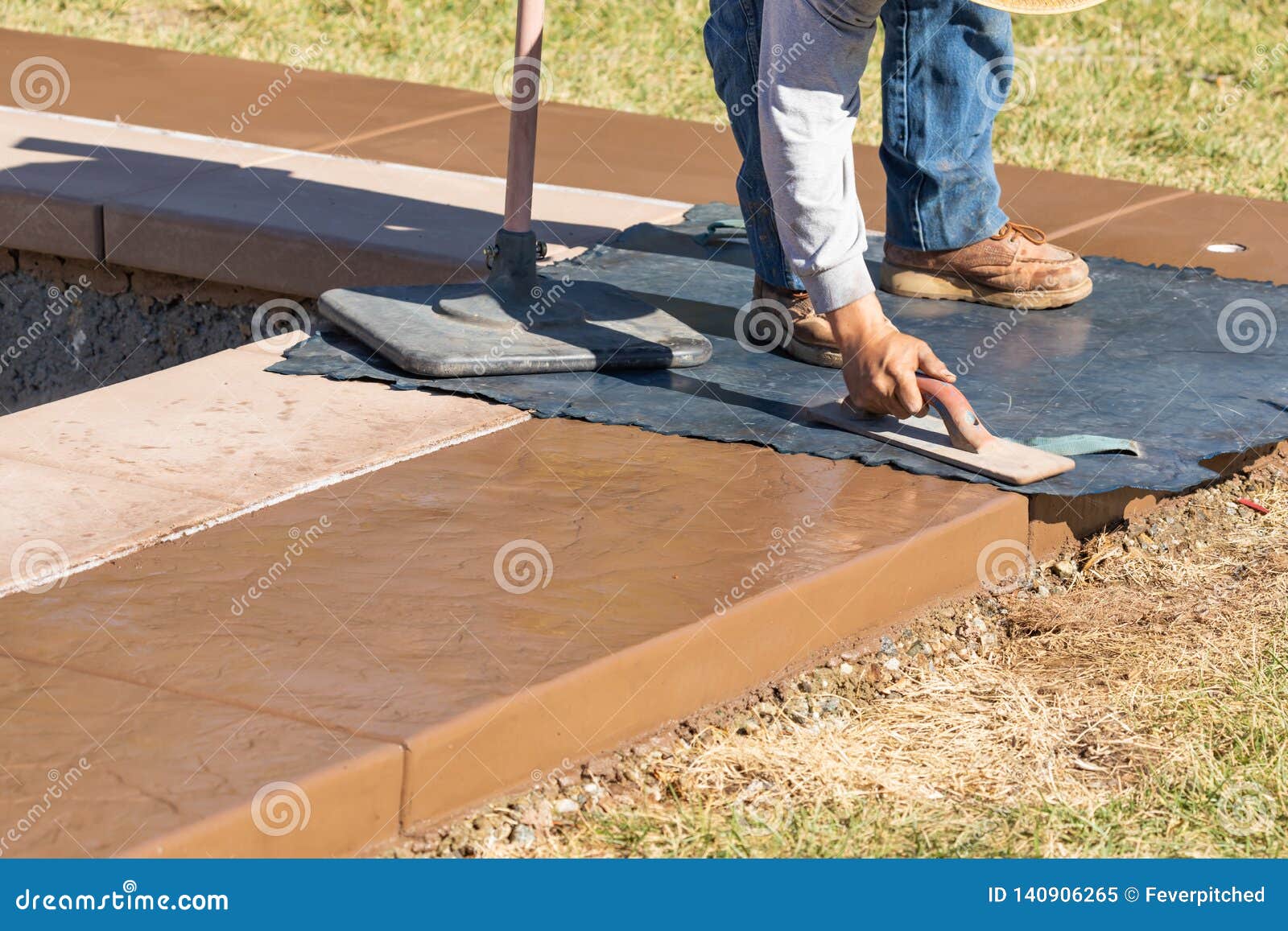 Construction Worker Applying Pressure To Texture Template on Wet Cement ...