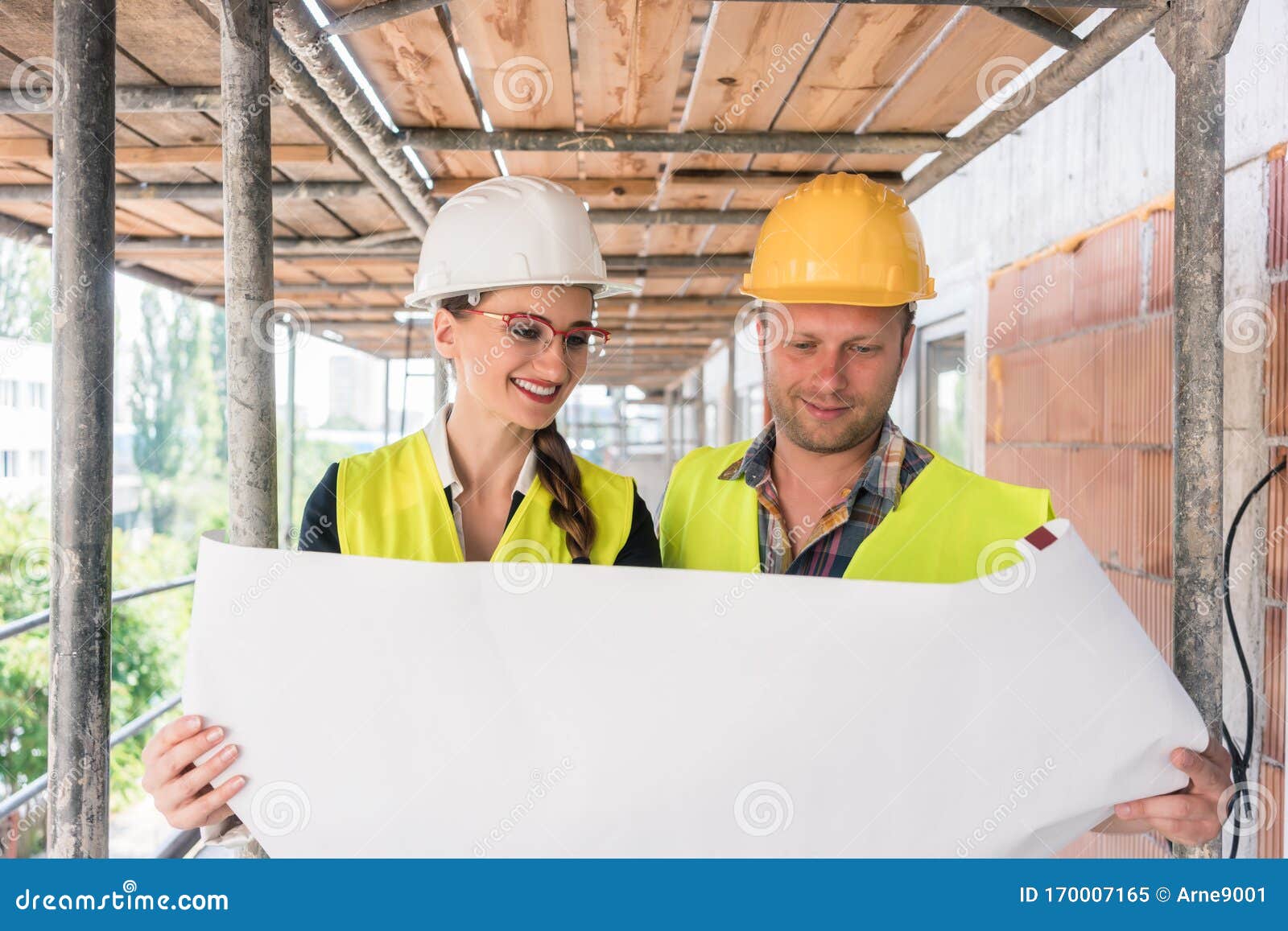 Construction Worker and Builder on Scaffolding Reading the Plan Stock ...