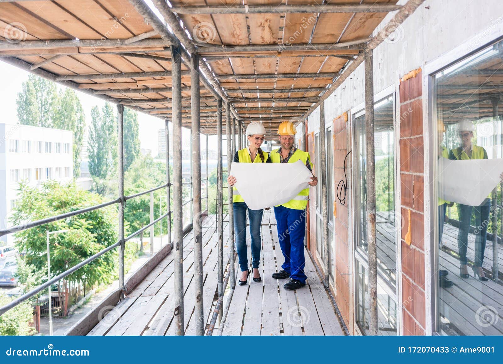 Construction Worker and Builder on Scaffolding Reading the Plan Stock ...