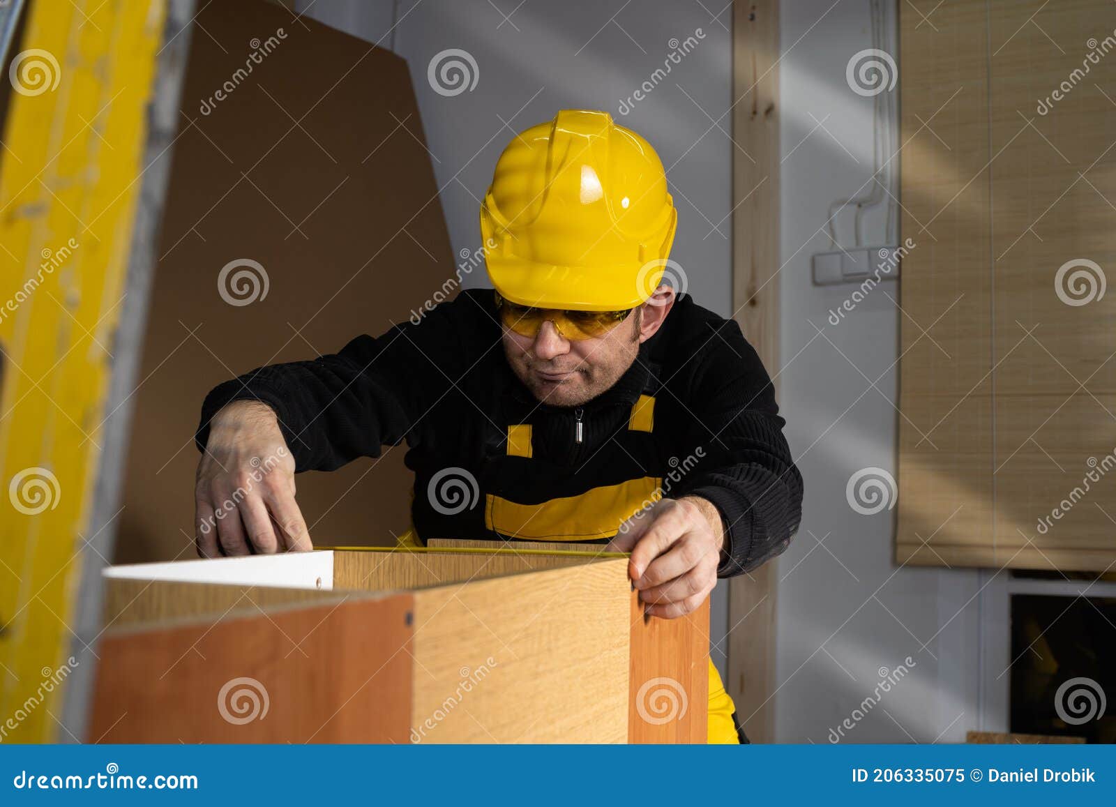 A Construction Worker Checks a Pull-out Cupboard at the Top with a Tape ...