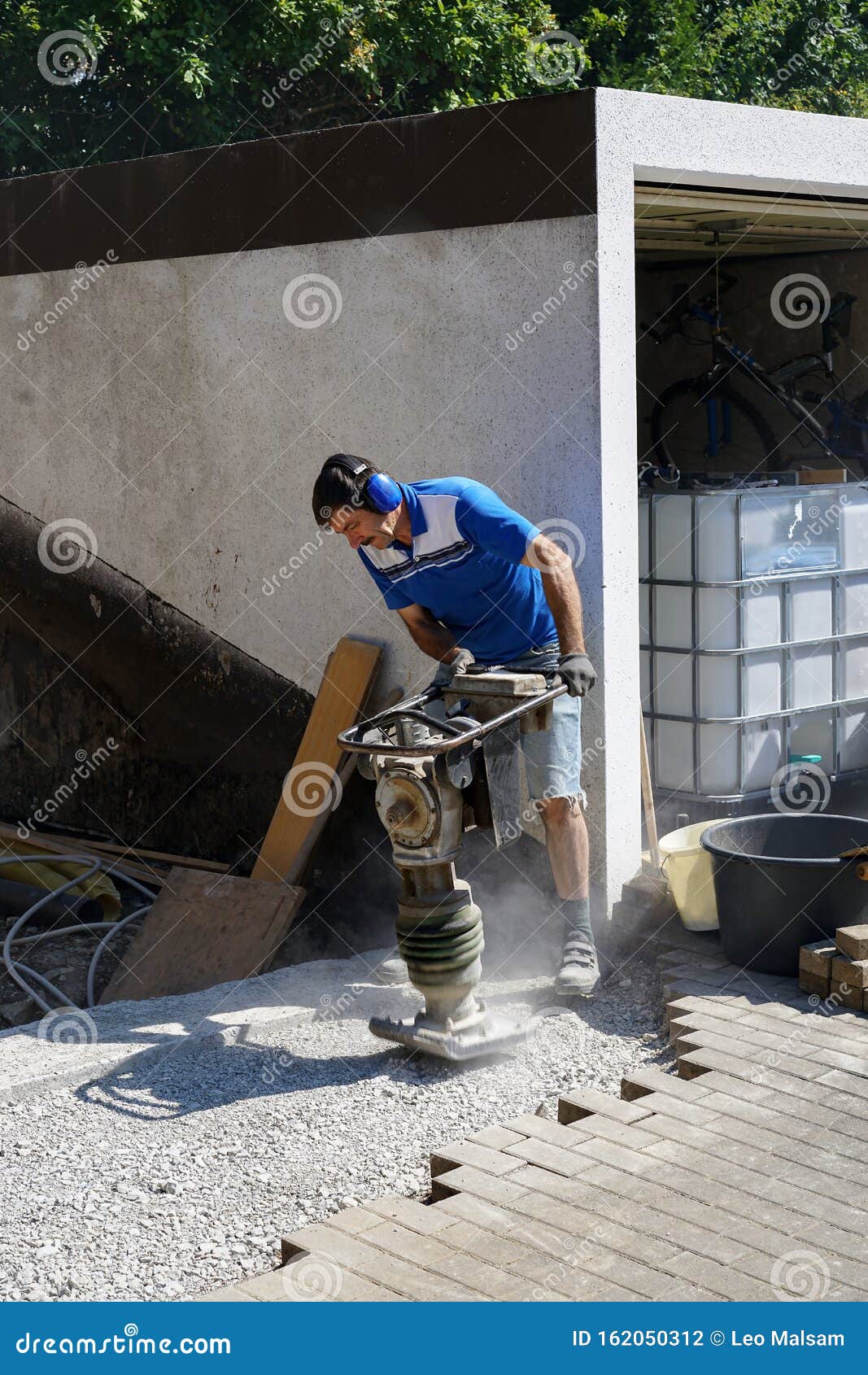 Construction Worker Compacting Soil Using Compactor. Work with Tamping ...