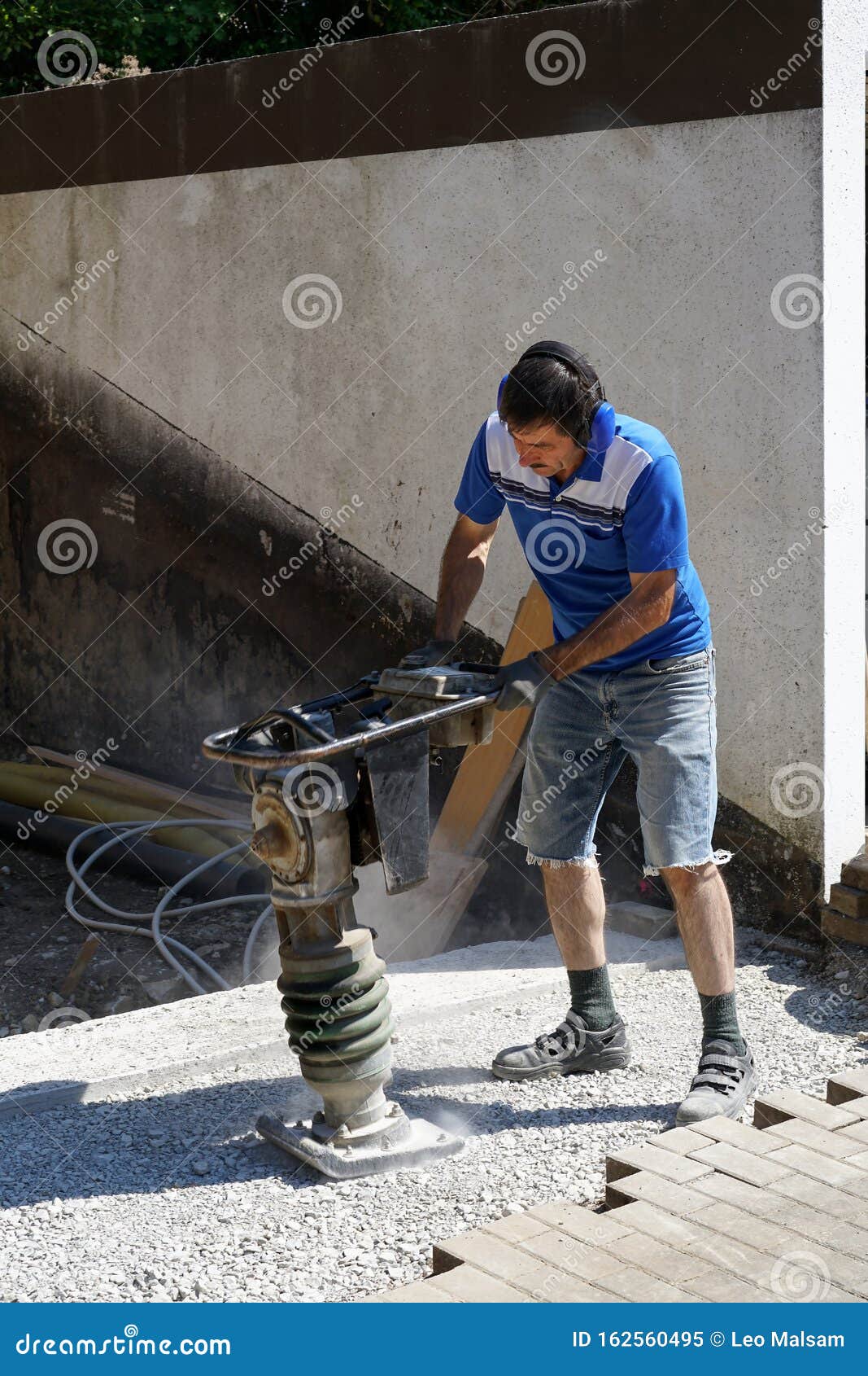 Construction Worker Compacting Soil Using Compactor. Work with Tamping ...