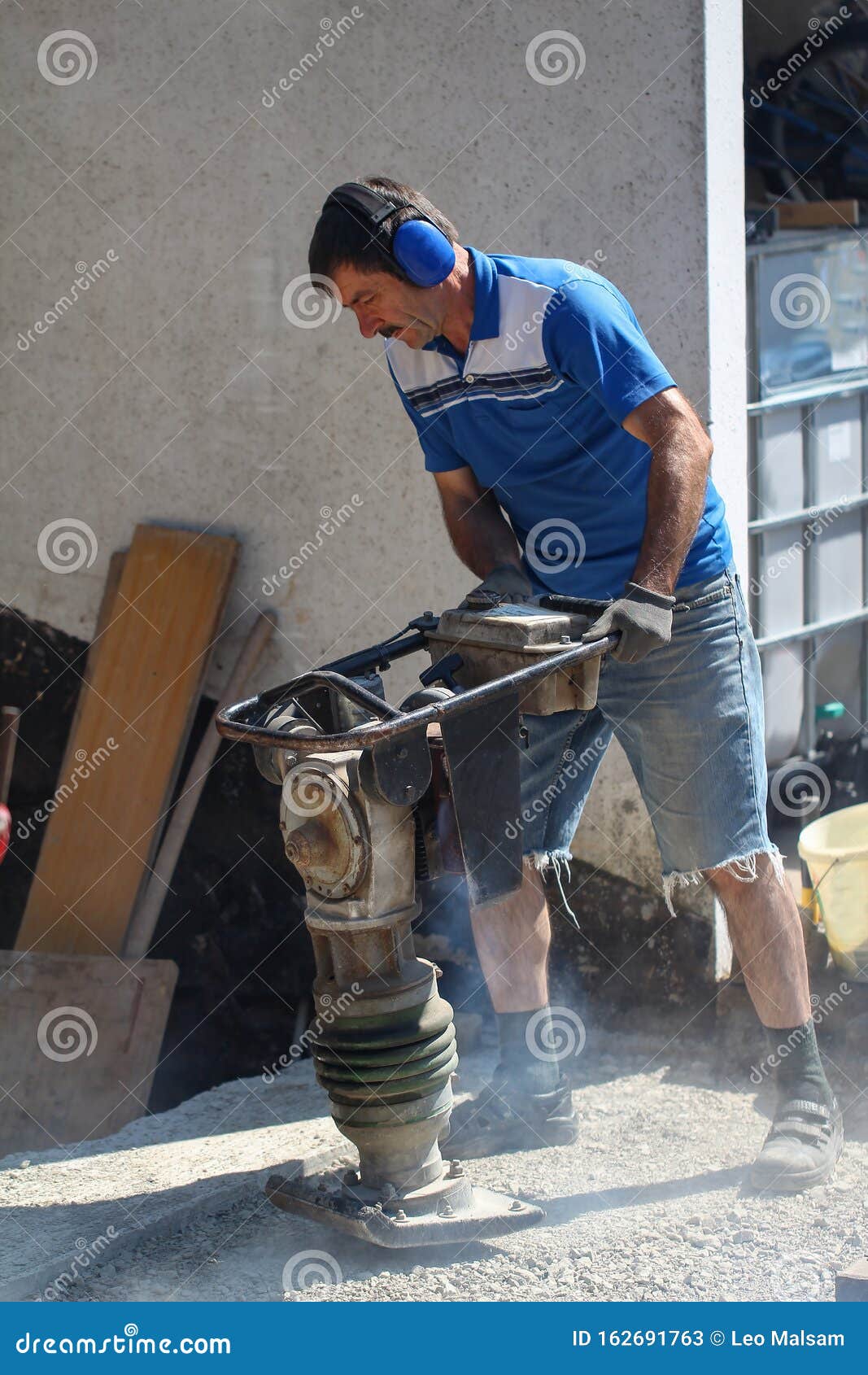 Construction Worker Compacting Soil Using Compactor. Work with Tamping ...