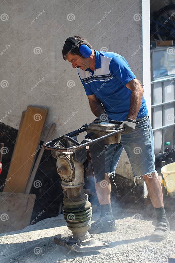 Construction Worker Compacting Soil Using Compactor. Work with Tamping ...