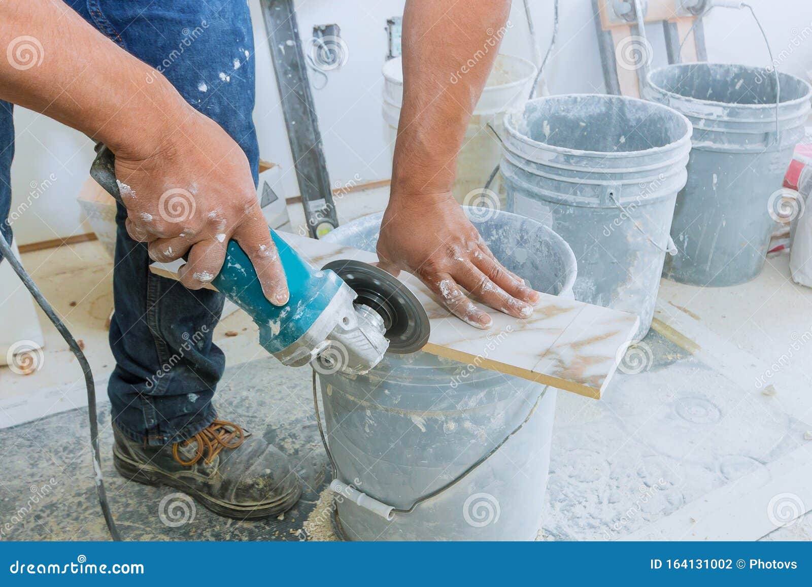A Construction Worker Cutting a Tile Using Grinder Stock Photo - Image ...