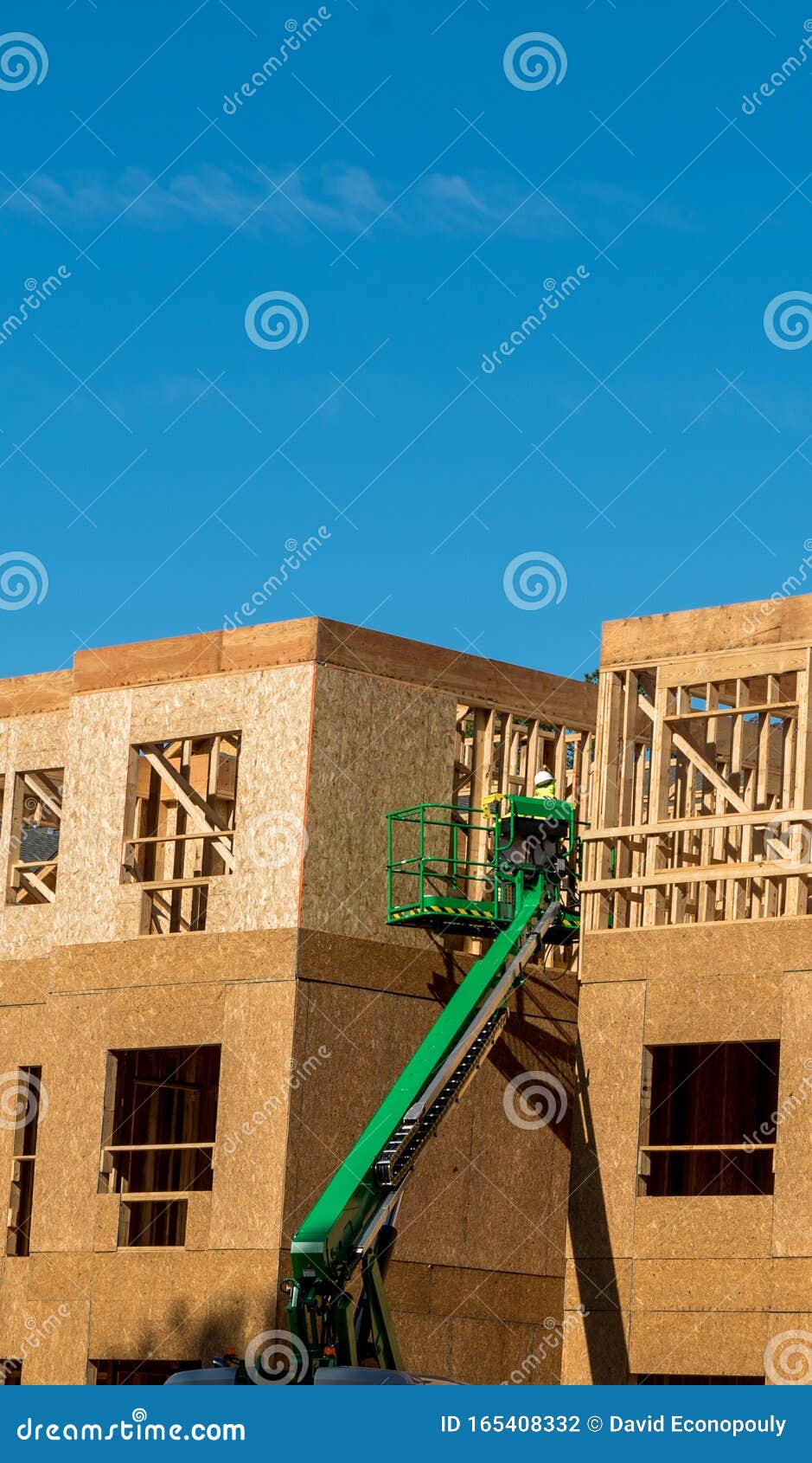 Construction Worker Elevated in Hydraulic Platform Working on Building ...