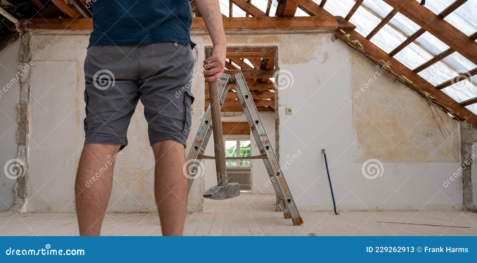 Construction Worker with a Hammer during the Renovation of the Attic of ...