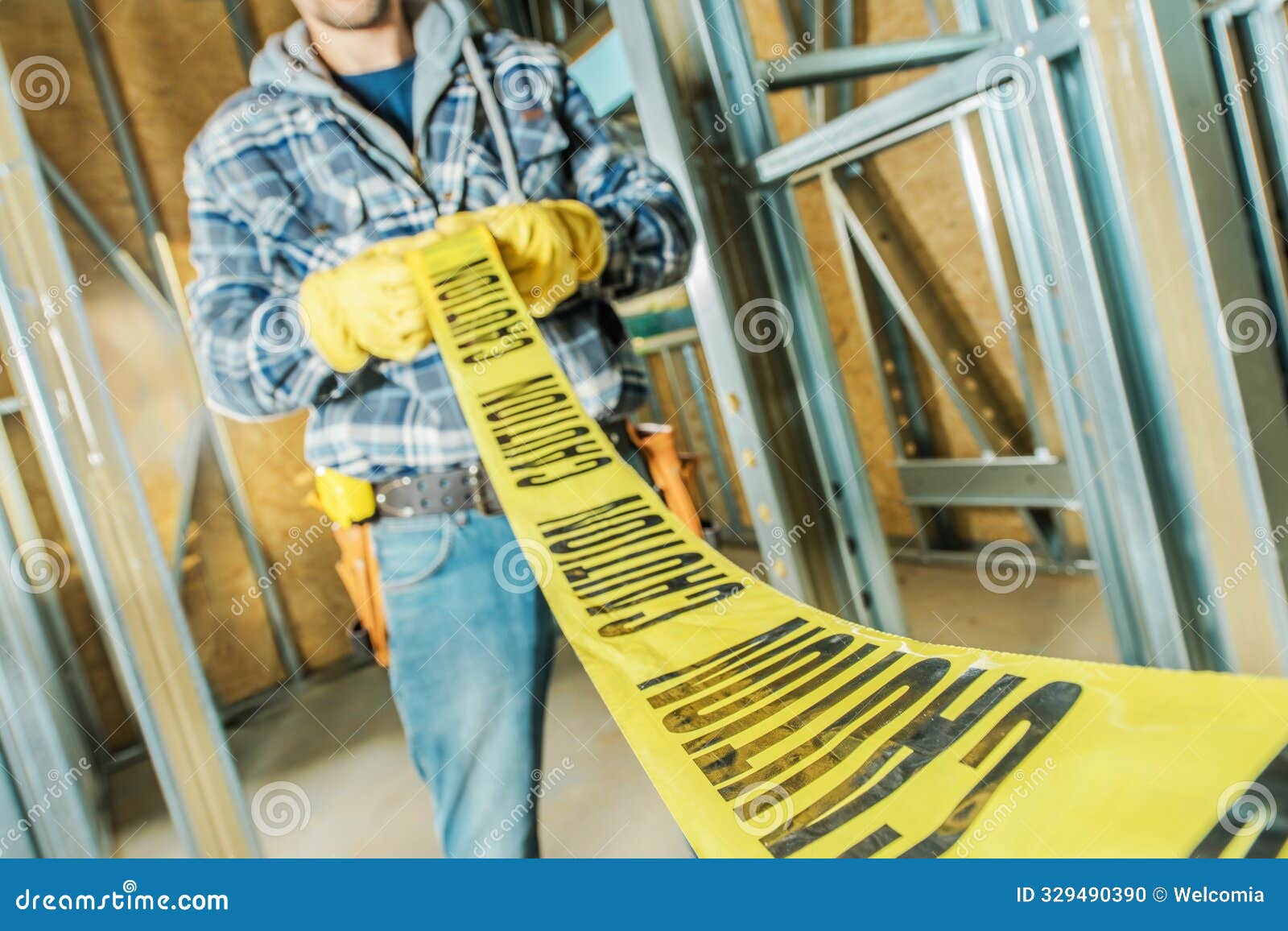 Construction Worker Handling Caution Tape at a Building Site during ...