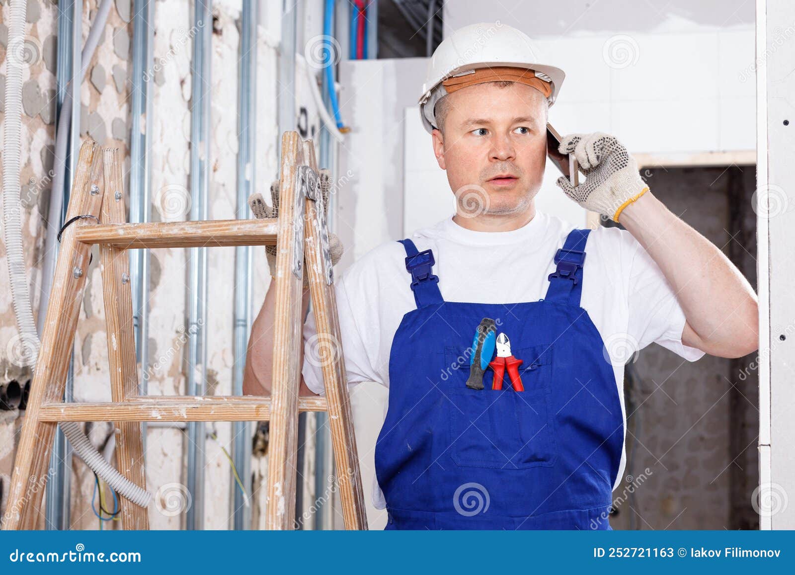 Construction Worker Having Serious Phone Conversation at Indoors ...