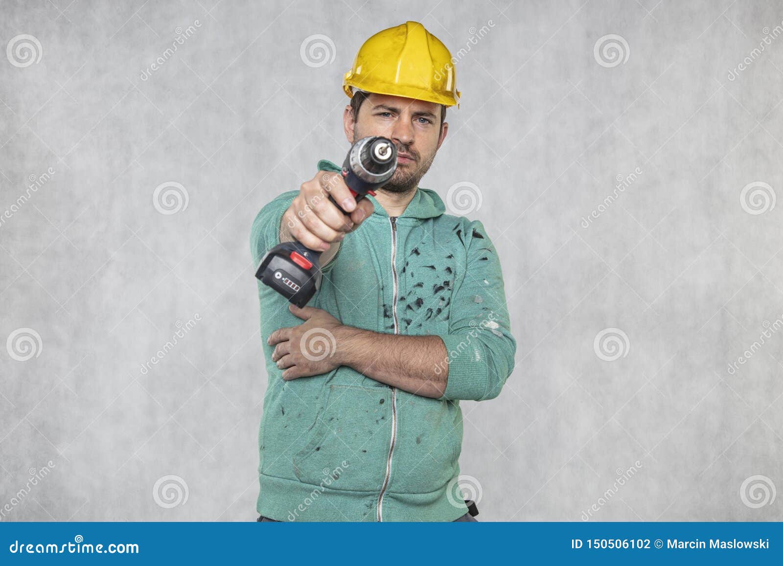 The Construction Worker Holds an Electric Screwdriver in His Hand ...
