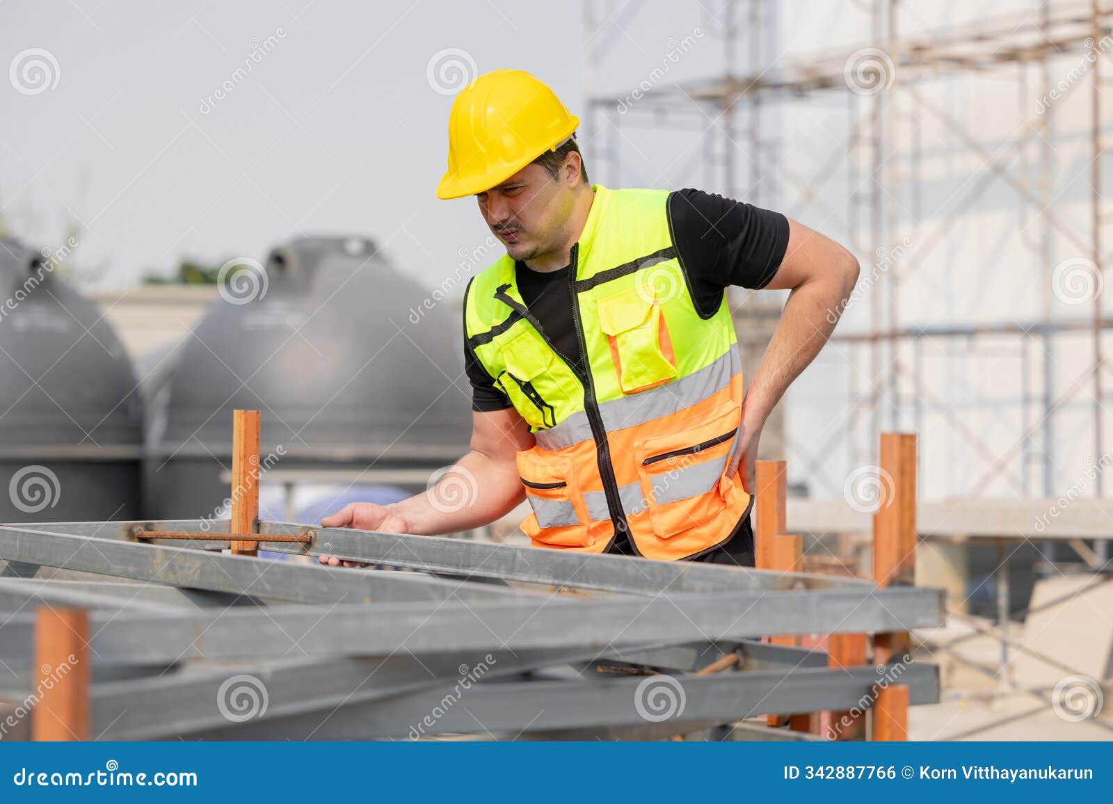 Construction Worker Inspecting Structure and Experiencing Low Back Pain ...