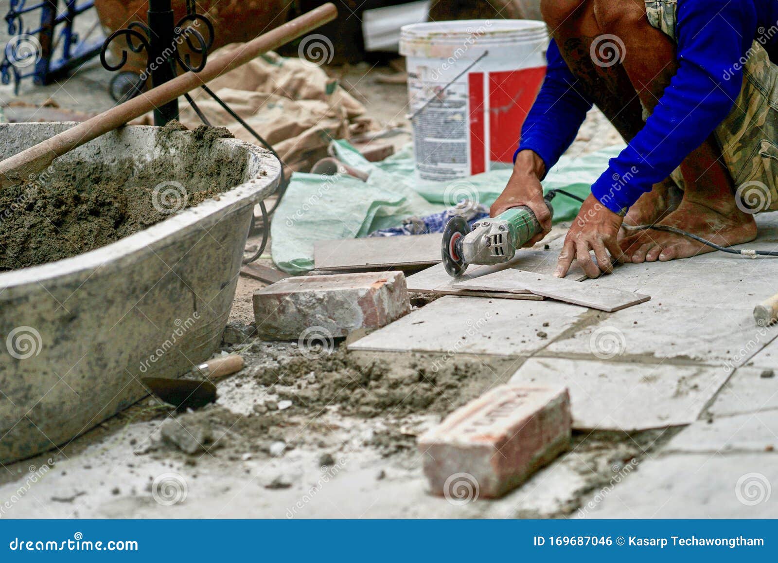 Construction Worker Installing Ceramic Tiles on a Floor . Tiling Floor ...