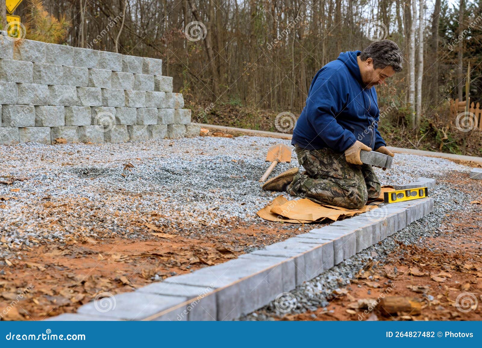 A Construction Worker Installing Concrete Pavers Stones on the ...