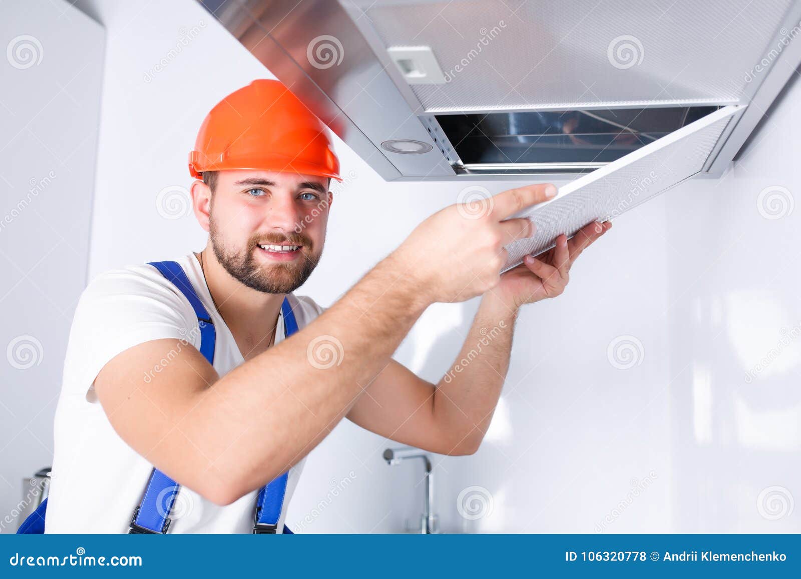 A Construction Worker, Installs a Suspended Hood in the Kitchen. Stock ...