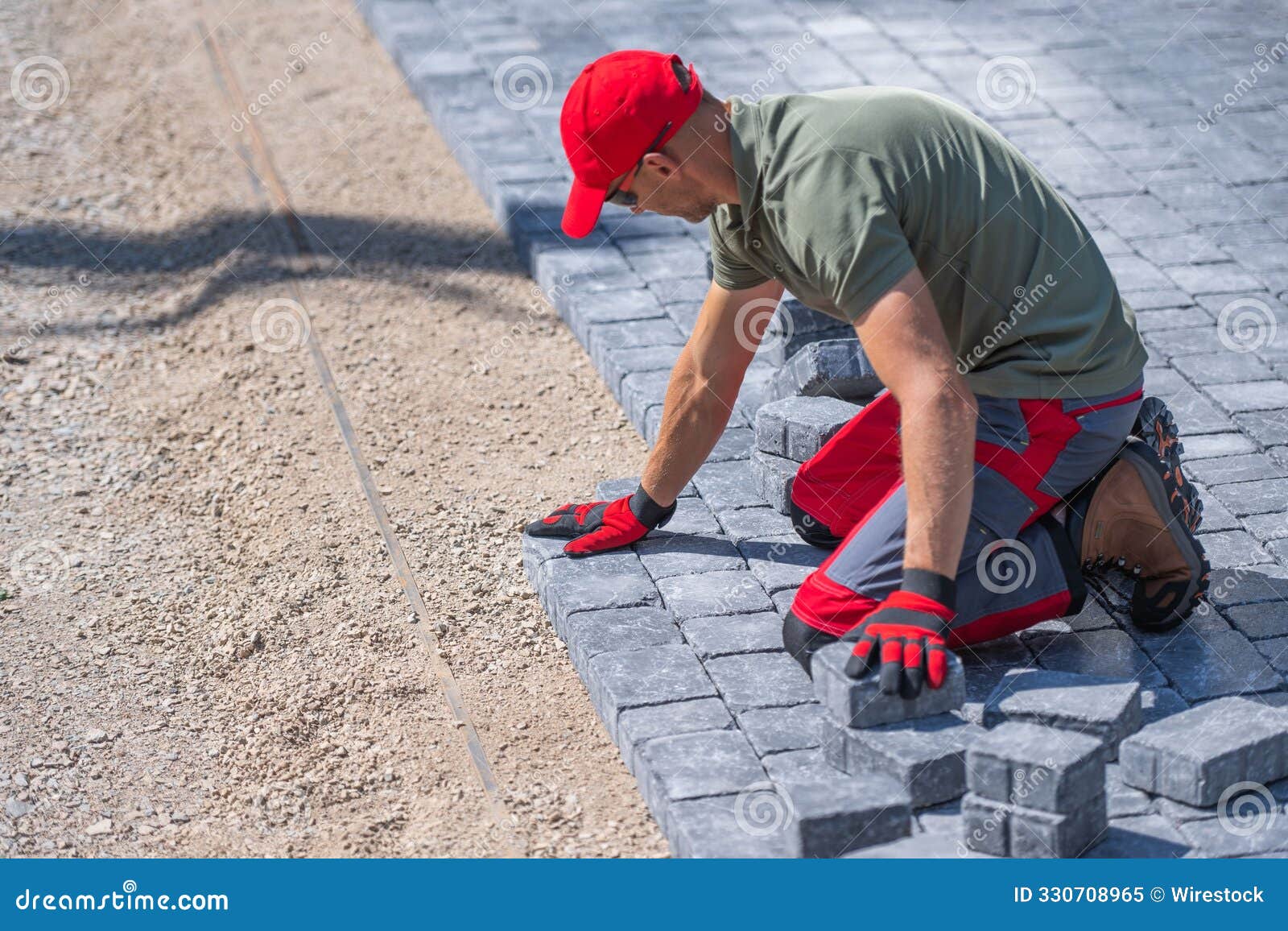 Construction Worker Laying Paving Stones on a Pathway at a Construction ...