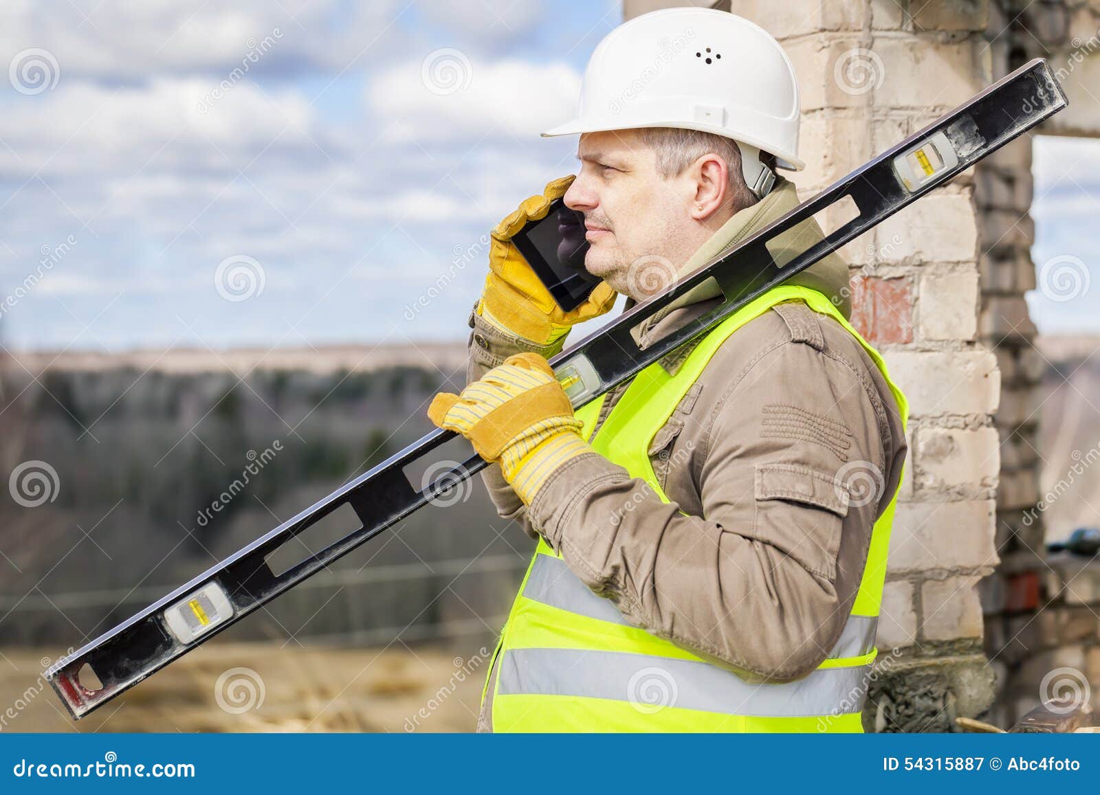Construction Worker with Level and Cell Phone Stock Image - Image of ...