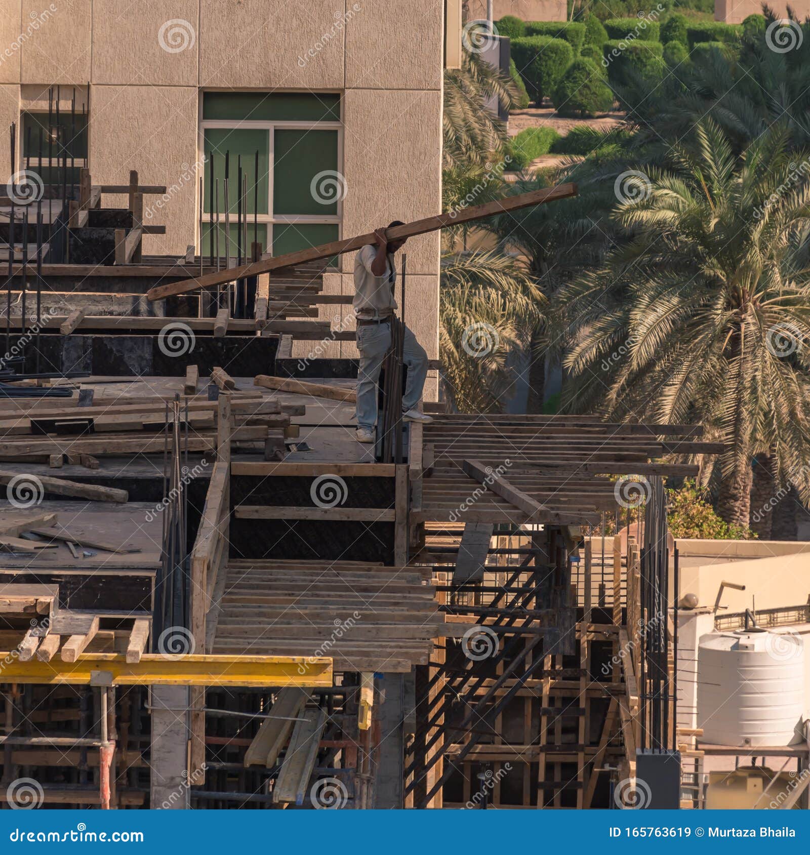 Construction Worker Lifting Heavy Load on Building Site Stock Image ...