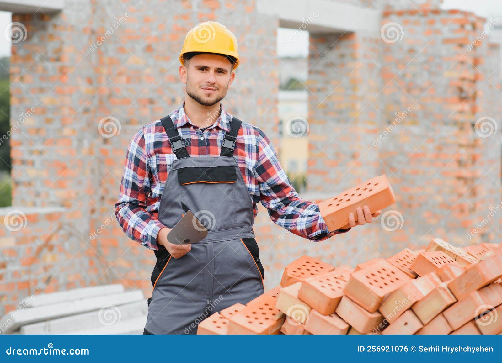Construction Worker Man in Work Clothes and a Construction Helmet ...