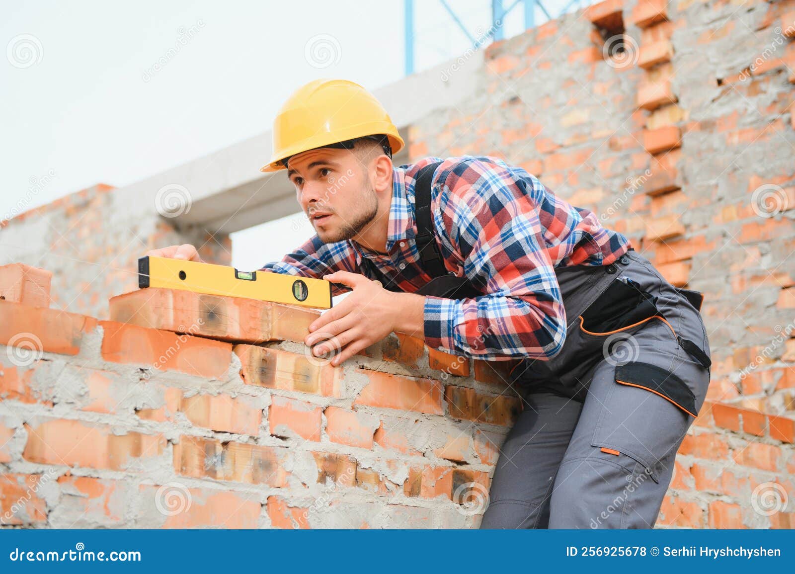 Construction Worker Man in Work Clothes and a Construction Helmet ...