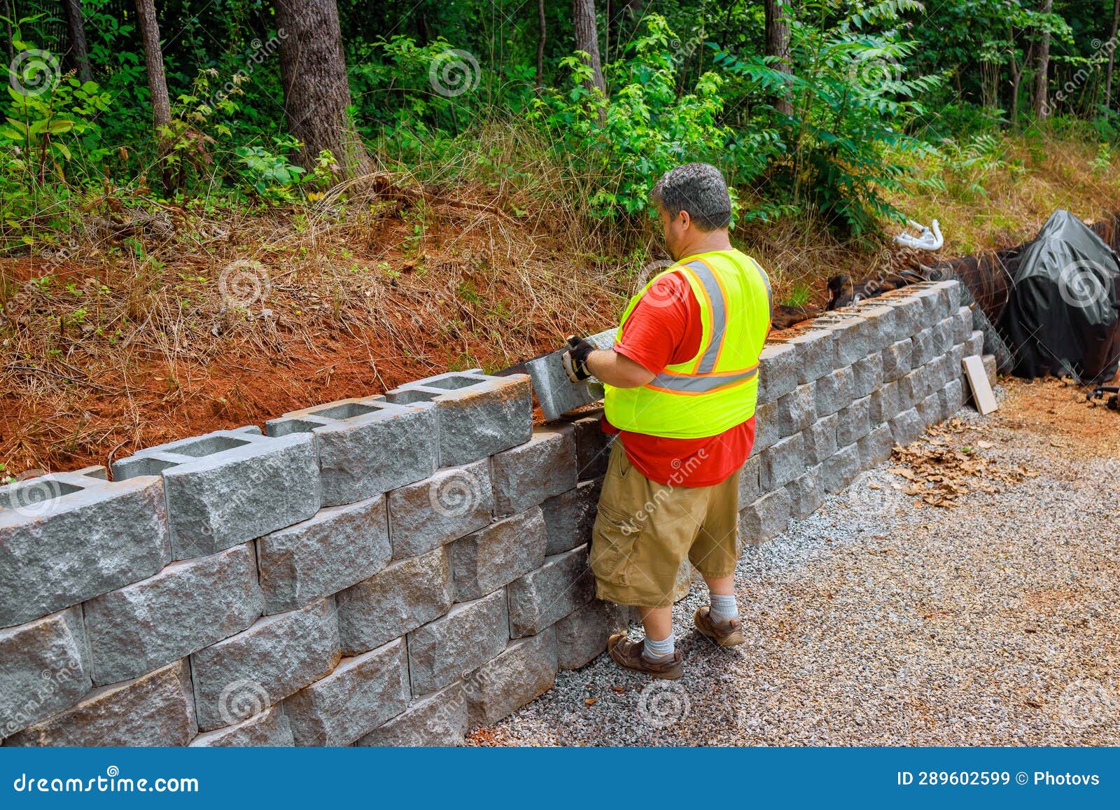 A Construction Worker Mounted Concrete Blocks To Retaining Wall on ...