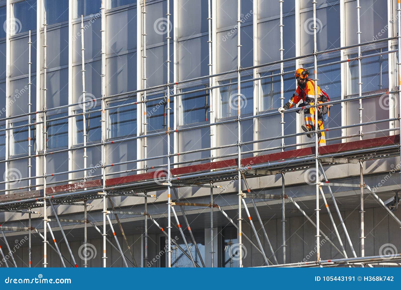 Construction Worker Mounting a Scaffolding Structure on a Building ...