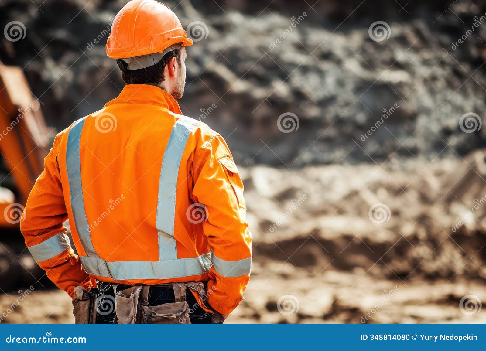 Construction Worker Observing Site Progress at a Busy Construction Zone ...
