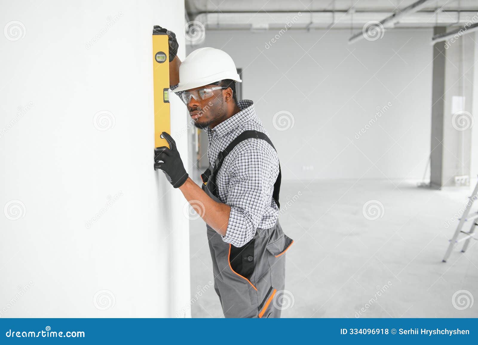 Construction Worker Observing and Surveying Wall Alignment Using Water ...