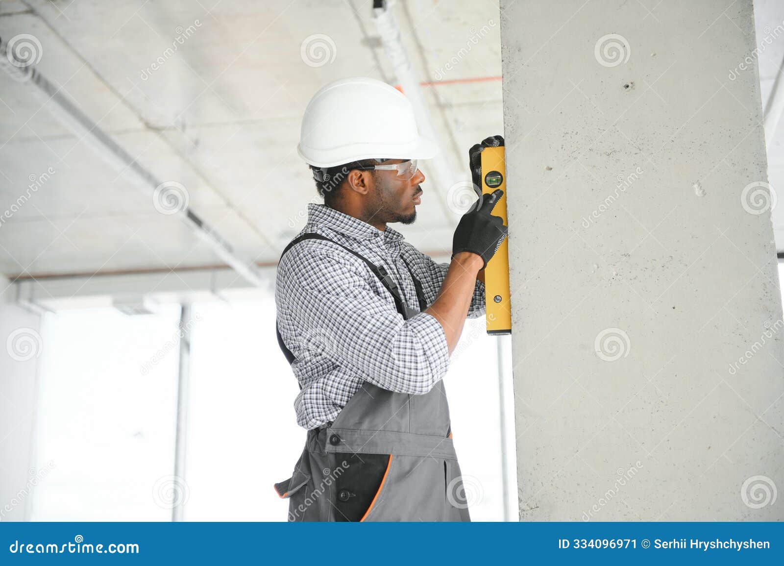 Construction Worker Observing and Surveying Wall Alignment Using Water ...