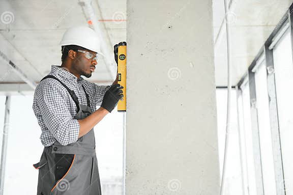 Construction Worker Observing and Surveying Wall Alignment Using Water ...