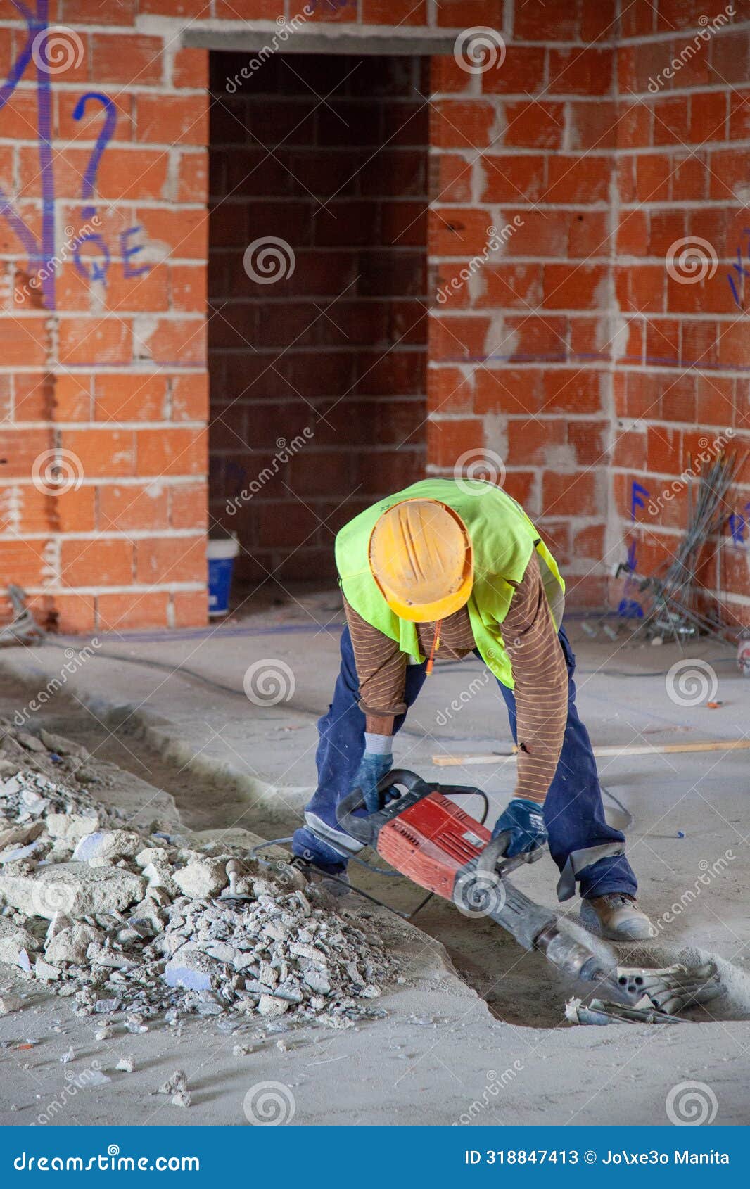 A Construction Worker Operates a Jackhammer, Breaking Ground during a ...
