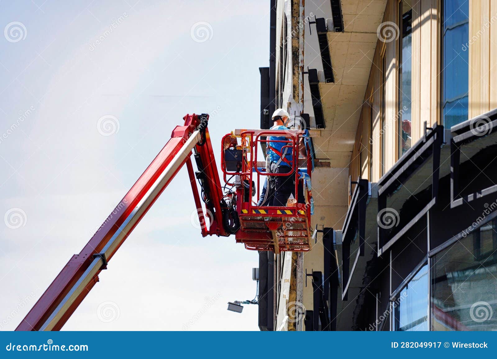 Construction Worker Operating a Cherry Picker while Working on a ...