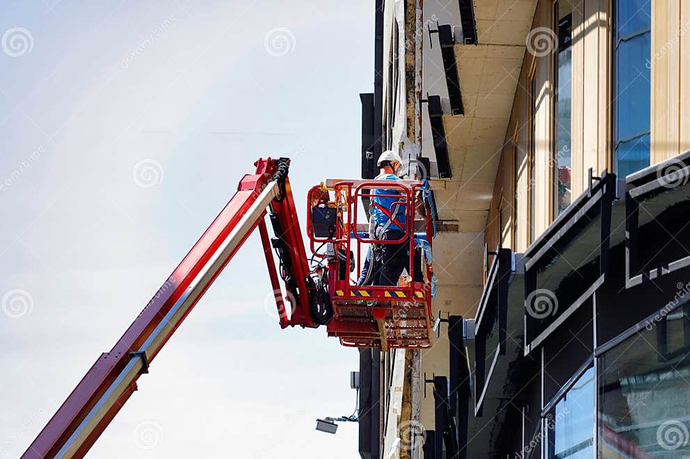 Construction Worker Operating a Cherry Picker while Working on a ...