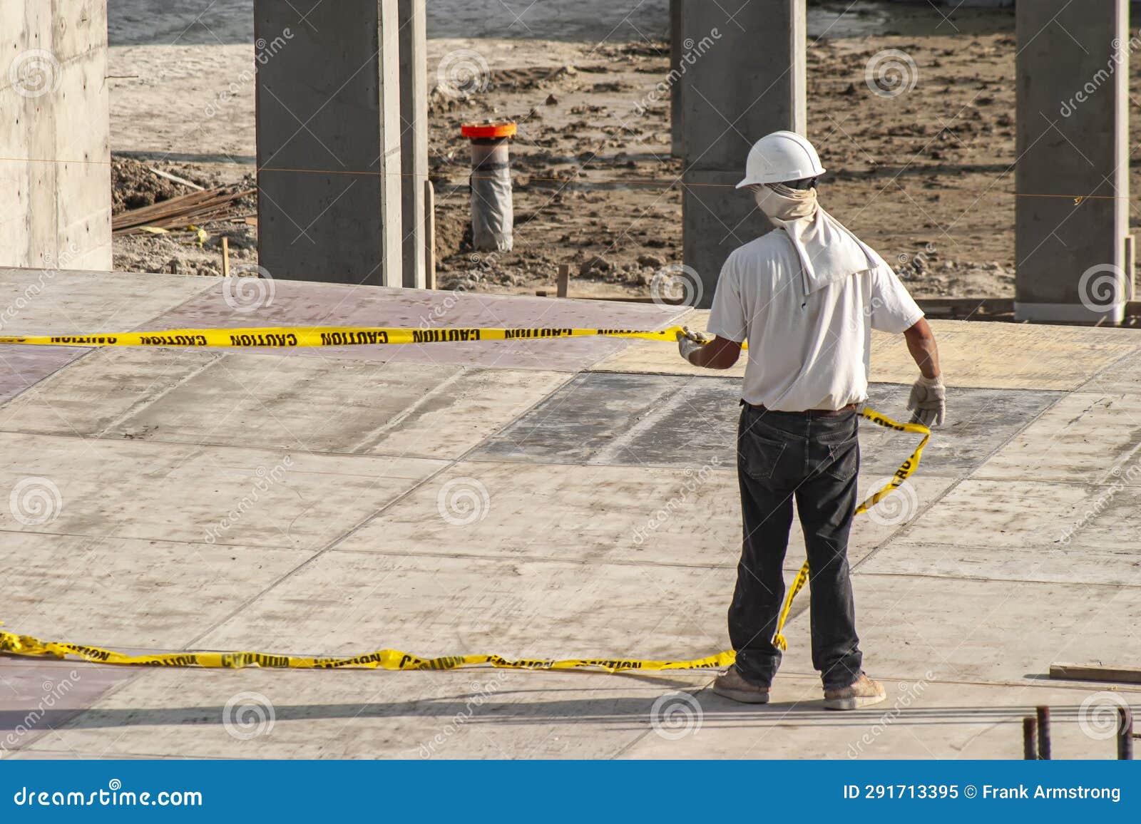 Construction Worker Placing Caution Tape at a Parking Structure Project ...