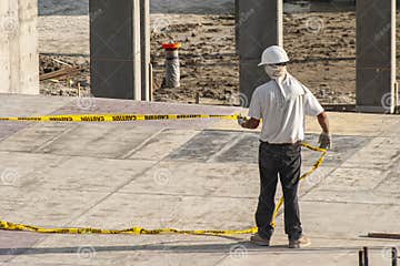 Construction Worker Placing Caution Tape at a Parking Structure Project ...