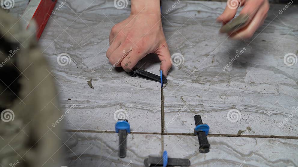 Construction Worker Placing Tile Leveling System Clips during ...
