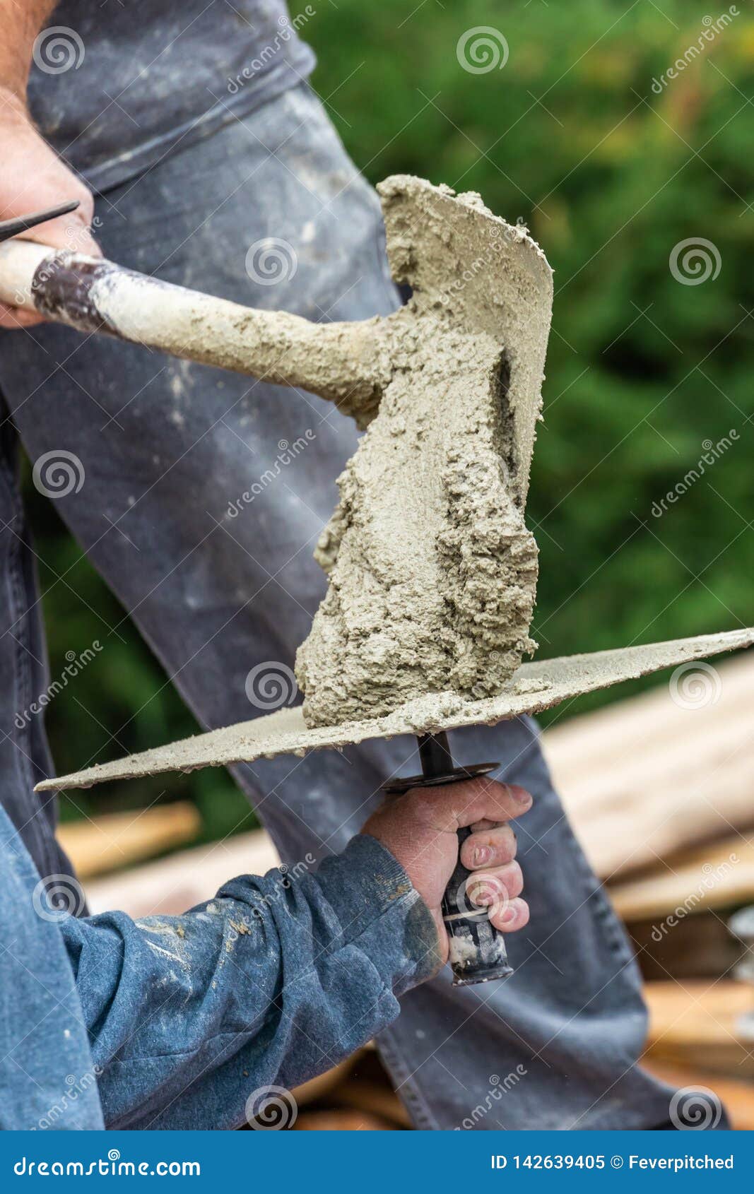 Construction Worker Placing Wet Cement on Platter for Tile Worker at ...